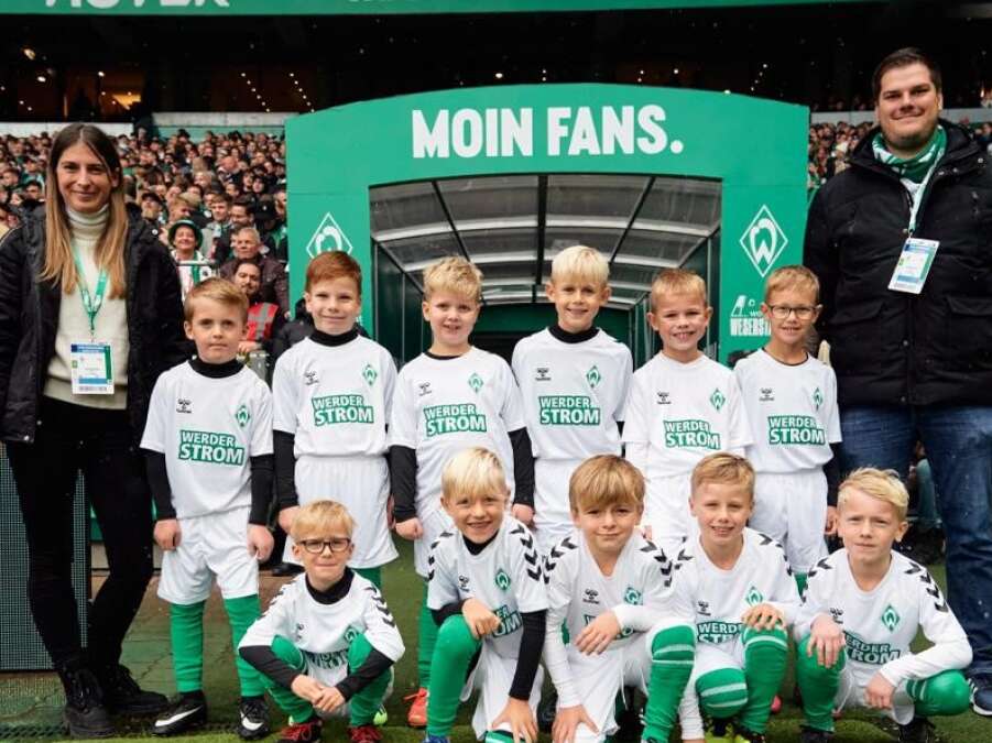 Nachwuchskicker des TSV Abbehausen laufen mit Werder-Profis in das ...
