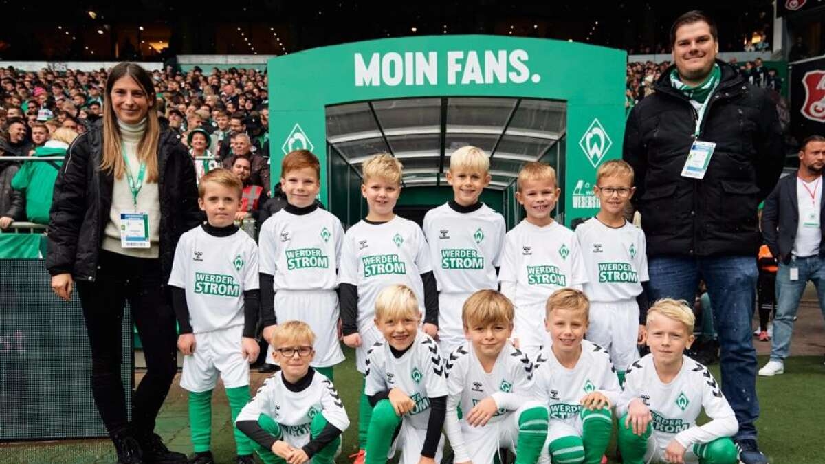 Nachwuchskicker des TSV Abbehausen laufen mit Werder-Profis in das ...